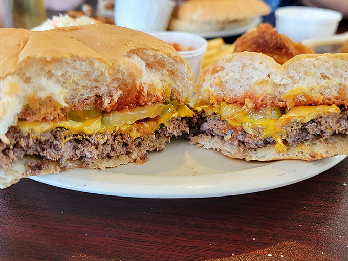 The cross-section of this patty melt reveals the truth: perfectly melted cheese, caramelized onions, and a beef patty cooked just right. Sandwich architecture at its finest.