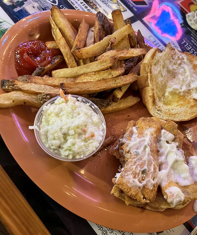 Seafood sandwich nirvana! Crispy perch nestled in a soft bun with those impossibly good fries—proof that sometimes the best ocean flavors are found riverside.