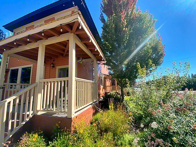 Cottage gardens and mountain sunshine create the kind of porch scene that makes you want to cancel all your appointments and stay another week.
