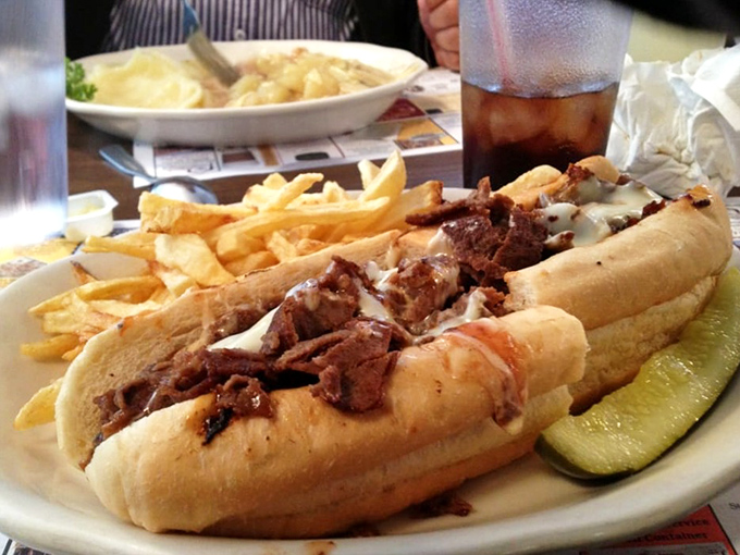 This cheesesteak isn't just a sandwich; it's a masterclass in the art of comfort food, complete with a pickle sidekick for balance.