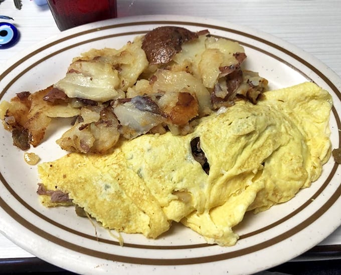 This omelet doesn't just satisfy hunger – it negotiates peace treaties with it. Golden exterior, melty interior, and home fries that demand equal attention.
