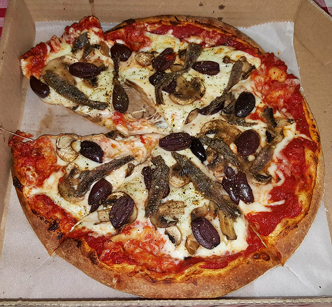 Even the pizza gets the smoky treatment here. Those mushrooms and olives aren't just toppings&mdash;they're supporting actors in a wood-fired drama.