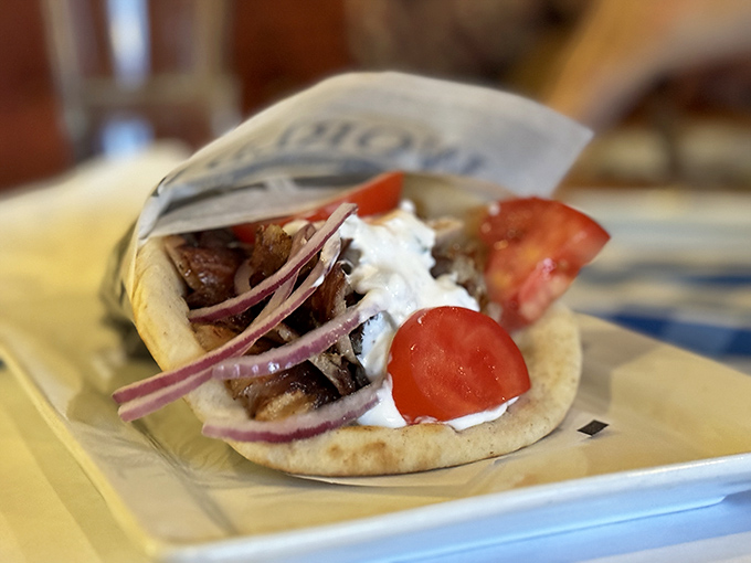 The pork belly gyro arrives like a love letter from Greece, each bite a perfect harmony of tender meat and bright toppings.