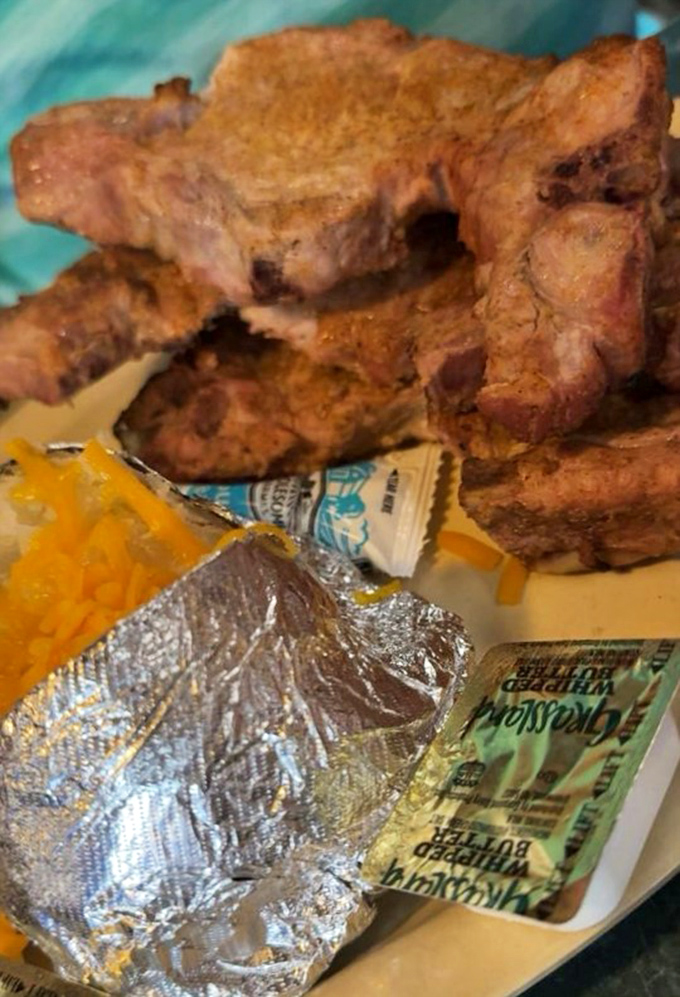 A thick, juicy pork chop takes center stage&mdash;so tender it could fall off its own bone. The foil-wrapped potato and cheese know they&rsquo;re just supporting actors in this show.