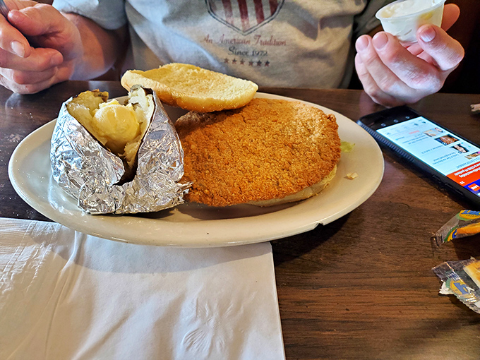 A breaded pork tenderloin sandwich that's practically wearing a superhero cape. That crispy coating is the stuff of Midwest legend, making the plate look like an afterthought.