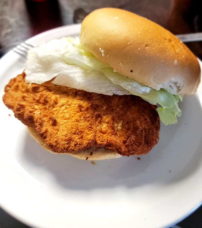 This pork tenderloin sandwich has clearly never heard of "fitting inside its bun"—a Midwest tradition that refuses to be contained.