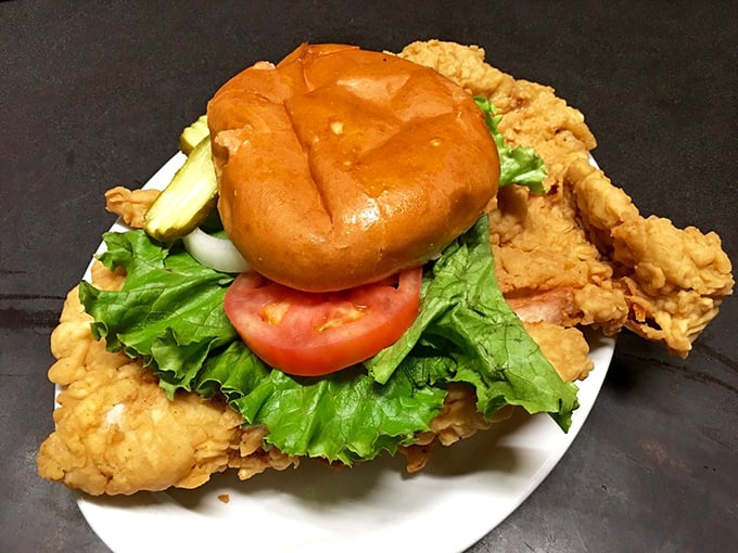 This pork tenderloin sandwich has clearly never heard of plate boundaries&mdash;the crispy, golden-fried masterpiece refuses to be contained by mere bread.