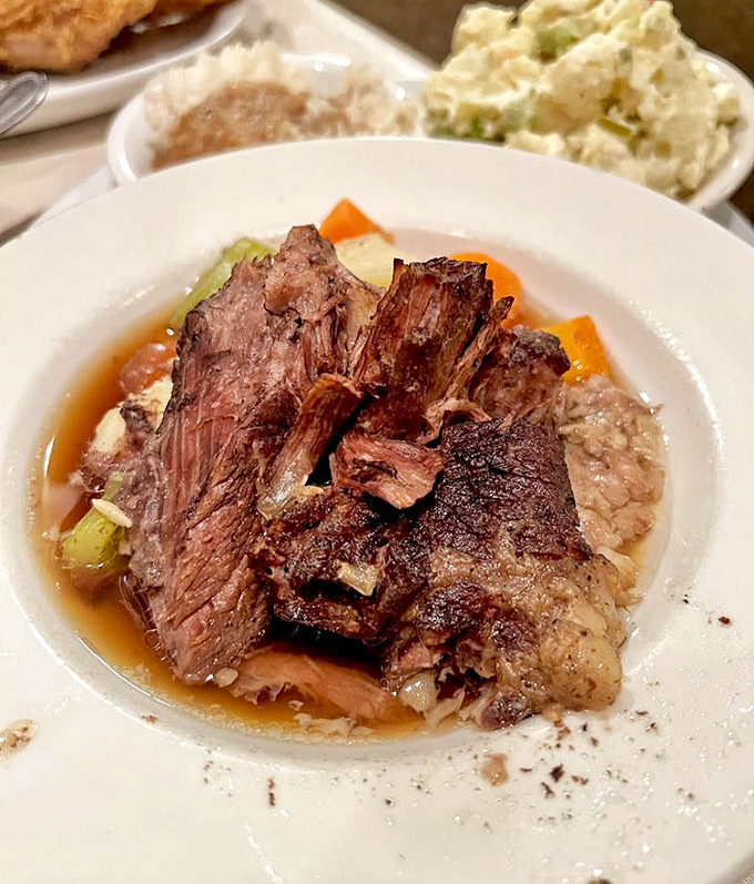 This pot roast isn't just dinner; it's a time machine to Sunday suppers where conversations flowed as freely as the savory gravy.