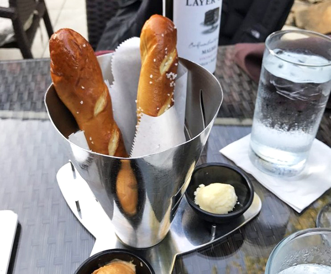 Pretzel breadsticks standing at attention in their metal vessel&mdash;warm, salty soldiers awaiting their orders to march toward butter.