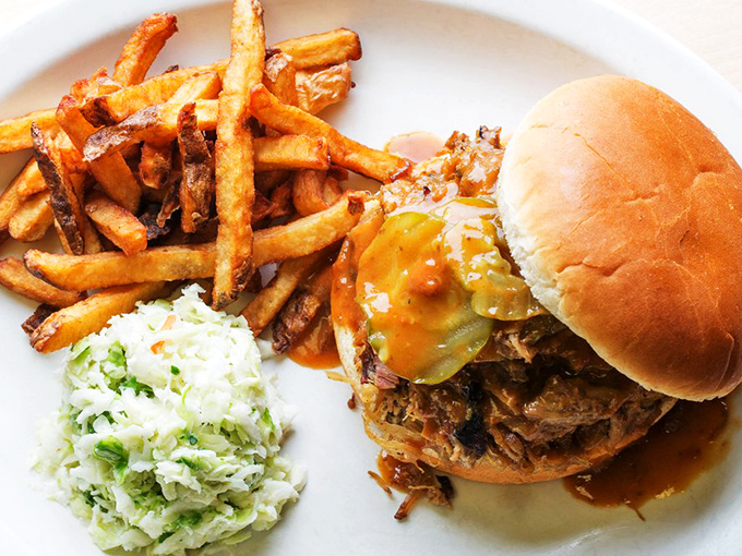 The perfect trifecta: smoky pulled pork, crispy fries, and cooling coleslaw. Some call it lunch; regulars call it therapy.