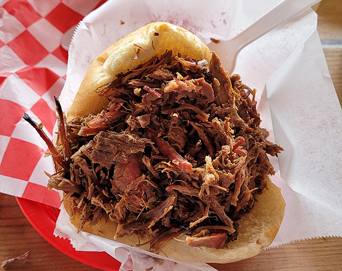 This pulled pork sandwich isn't just a meal&mdash;it's an edible hug. The bun barely containing its smoky, juicy contents like a parent trying to wrangle an enthusiastic toddler.