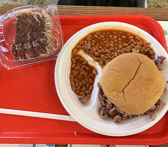 A pulled pork sandwich with beans that have clearly been simmering since the dawn of time. The bread's just there to help you maintain your dignity.