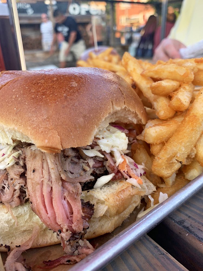 This pulled pork sandwich isn't just a meal &ndash; it's an architectural marvel of tender meat, tangy slaw, and a bun struggling heroically to contain it all.