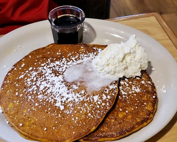 Golden pumpkin pancakes dusted with powdered sugar and topped with real whipped cream&mdash;breakfast that feels like dessert but somehow counts as a legitimate meal.