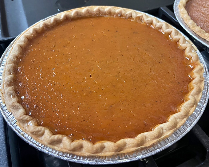Pumpkin pie so perfectly golden it belongs in Fort Knox. The crust-to-filling ratio here is what mathematicians call "the divine proportion of dessert."