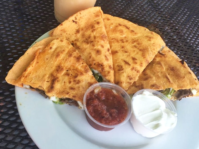 Quesadillas served with the holy trinity of accompaniments: salsa, sour cream, and the satisfaction of knowing you've made excellent life choices today.