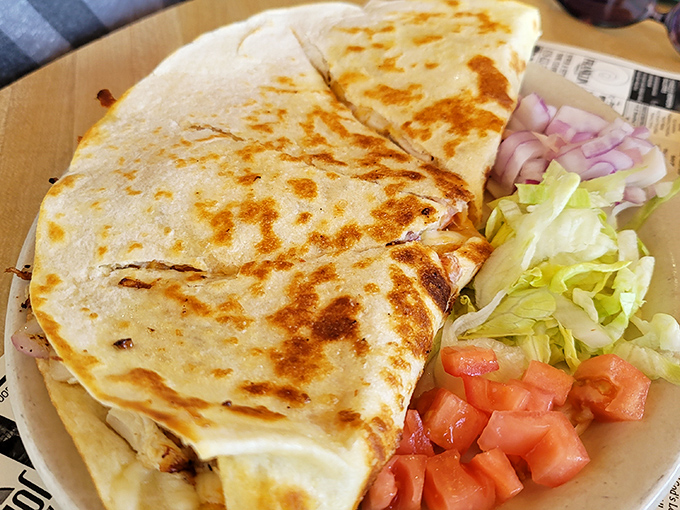This quesadilla isn't trying to win authenticity contests; it's just delivering melty, satisfying comfort with a side of fresh veggies for your island adventure fuel.