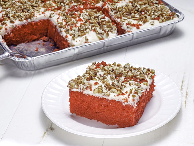 Red velvet cake that's redder than Alabama football jerseys, topped with enough pecans to make a squirrel consider breaking and entering.