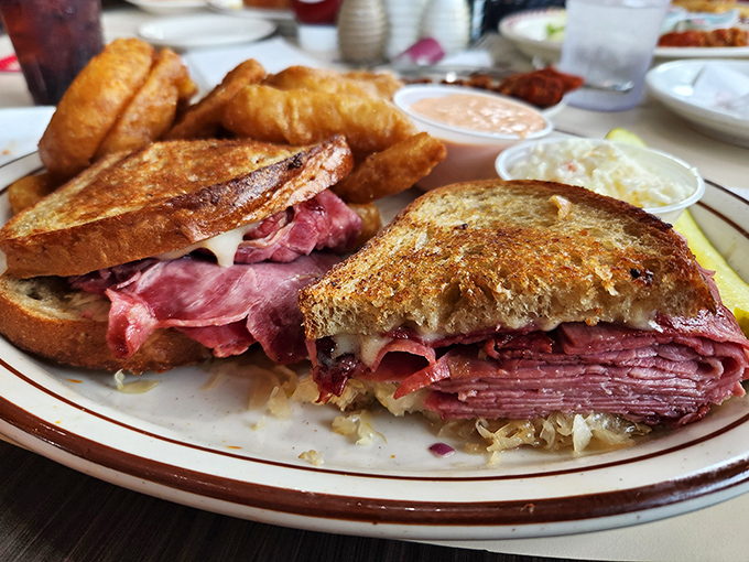This Reuben isn't just a sandwich; it's an engineering marvel of corned beef architecture that demands both hands and possibly a strategy session.