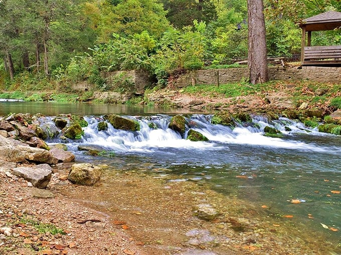 Nature's symphony in action &ndash; crystal clear waters tumble over moss-covered rocks while sunlight dapples through the trees, creating Missouri's perfect soundtrack.