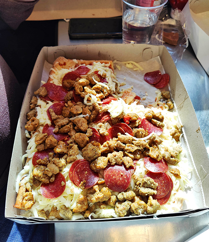 Pizza maximalism at its finest&mdash;pepperoni and sausage creating a meaty mosaic atop that signature cold cheese mountain. This isn't a topping situation; it's a topping celebration.