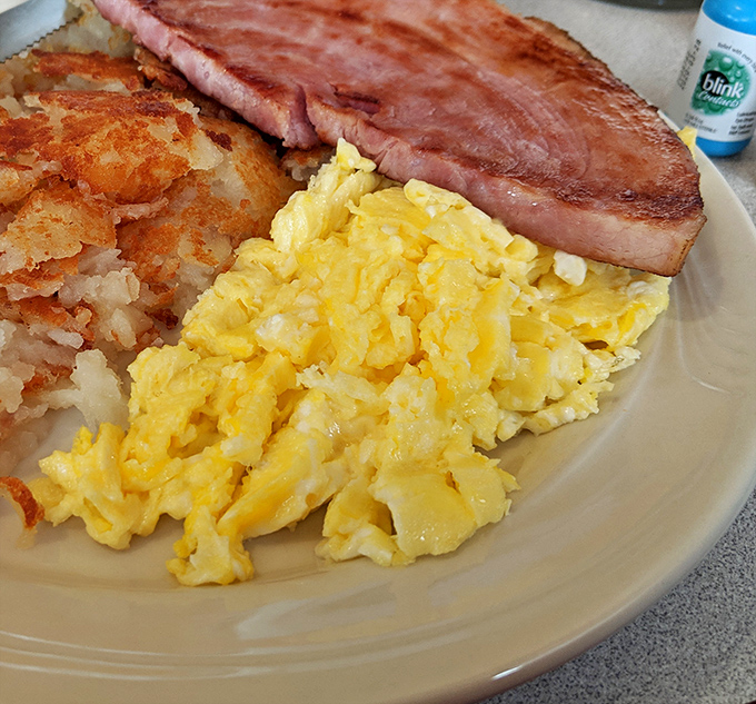 Classic breakfast done right: fluffy scrambled eggs, crispy hash browns, and ham thick enough to satisfy any appetite.