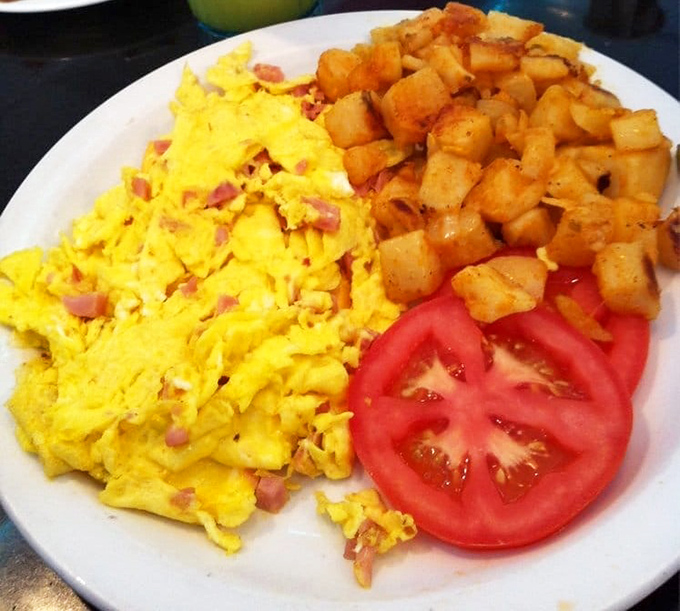 Scrambled eggs that look like sunshine on a plate, keeping company with home fries that have achieved golden-brown perfection.