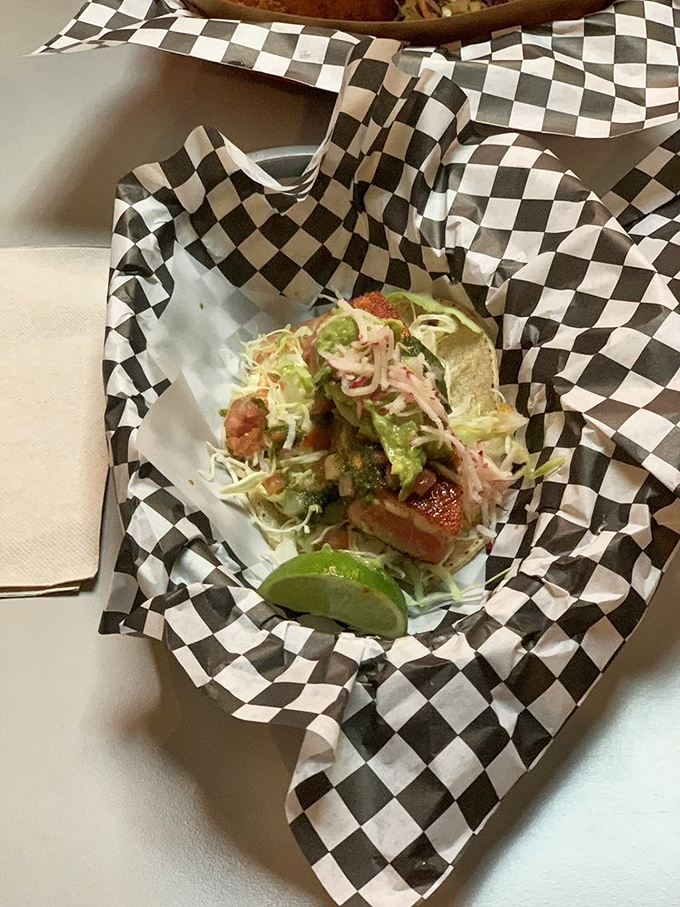 Fish tacos done right &ndash; crisp cabbage, creamy avocado, and perfectly cooked fish. That lime wedge isn't just decoration; it's the final high note in a culinary symphony.