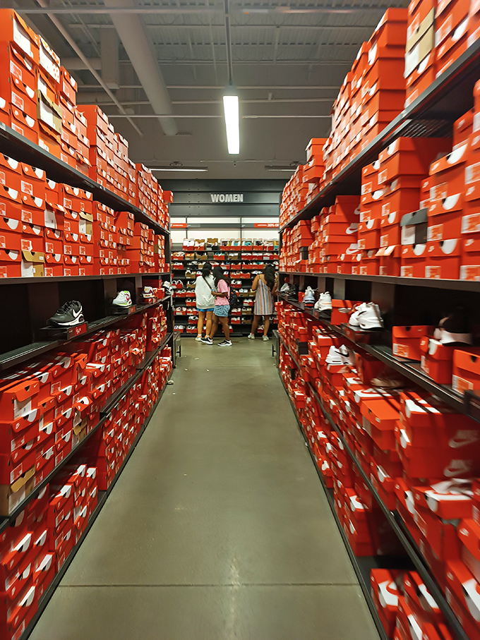 The Nike outlet's wall of orange boxes stretches like the Grand Canyon of footwear, a sneakerhead's dream landscape.