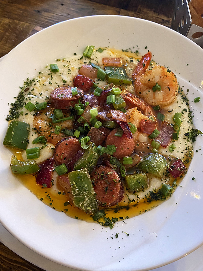 Shrimp and grits gets the royal treatment here &ndash; andouille sausage and peppers turning a southern classic into a breakfast symphony.