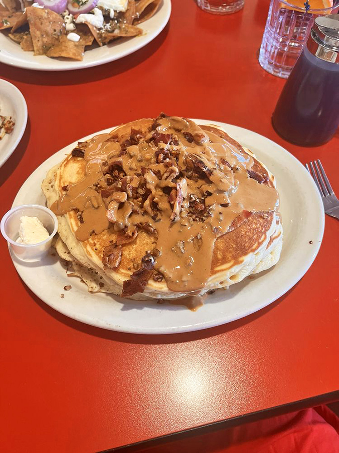 Behold the pancake stack that requires a topographical map to navigate&mdash;layers of fluffy goodness crowned with pecans and a river of syrup.