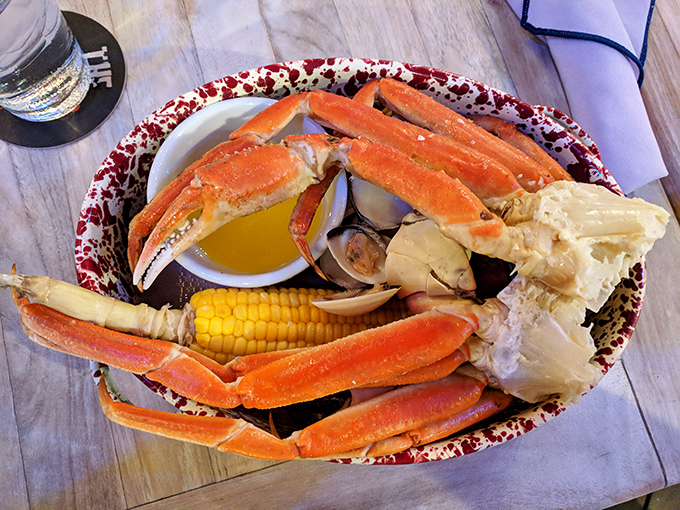 Snow crab legs stretching gloriously across the plate like they're sunbathing on a Key West beach, with corn on the cob playing happy neighbor.