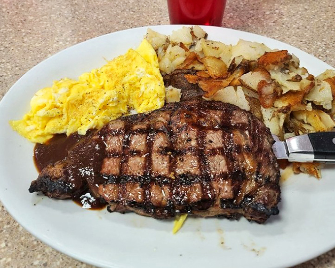This steak bears perfect grill marks that would make a professional pitmaster weep with joy. Paired with eggs and potatoes, it's the breakfast of champions.