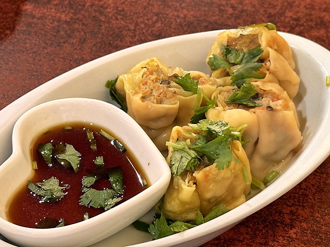 These golden steamed dumplings arrive with dipping sauce and the promise of savory filling wrapped in delicate, tender perfection.