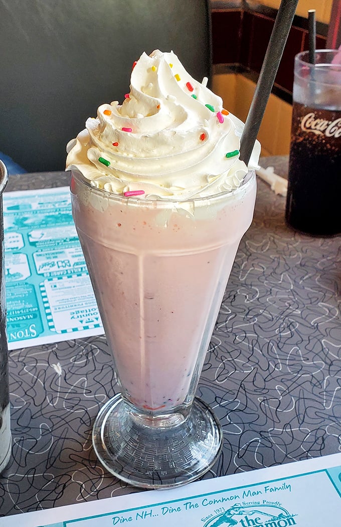 Whipped cream mountains rising from a strawberry shake valley. This isn't dessert&mdash;it's architecture with sprinkles, demanding both a spoon and straw strategy.