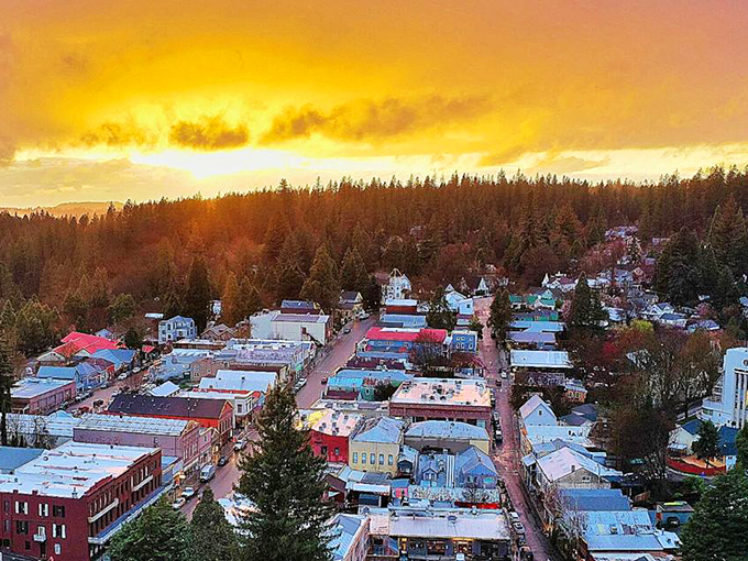 Golden hour transforms Nevada City into a painter's dream, where rooftops catch fire with sunset colors against a backdrop of evergreen sentinels.