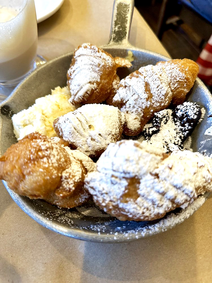 These beignets aren't just dusted with powdered sugar—they're practically wearing a snowstorm. Worth every telltale white fingerprint you'll leave on your dark clothes.