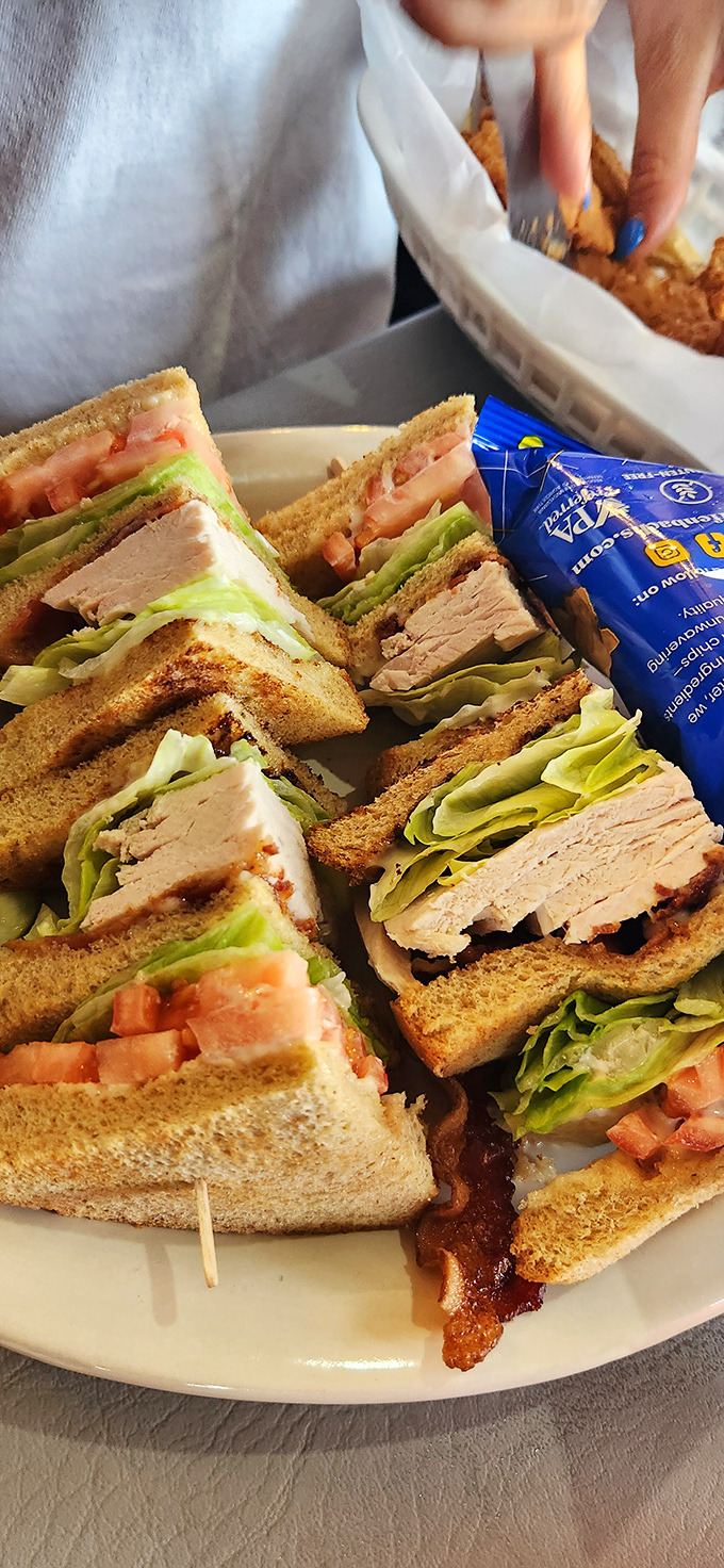 This isn't just a turkey club&mdash;it's architectural genius stacked between toasted bread, where each precisely cut quarter reveals layers of delicious engineering.