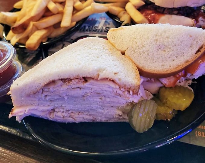 Layers of thinly-sliced turkey stack up like geological strata, each one telling the story of smoke, spice, and the patience required for proper barbecue.