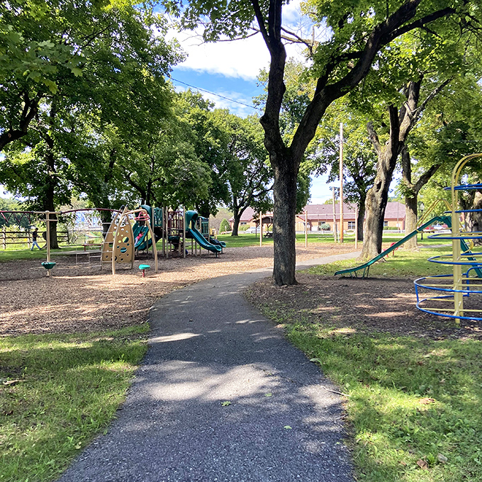 This playground whispers of childhood summers when "screen time" meant watching shadows dance through tree branches while waiting your turn on the swings.