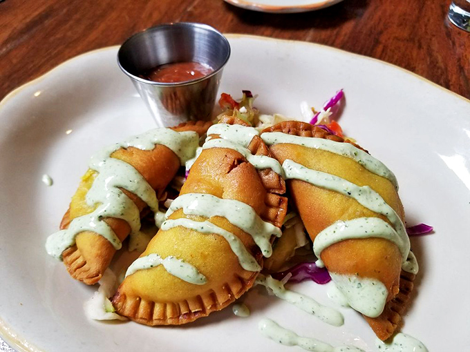 Golden empanada pockets drizzled with green sauce prove vegetables never looked this tempting or tasted this memorable at dinner.
