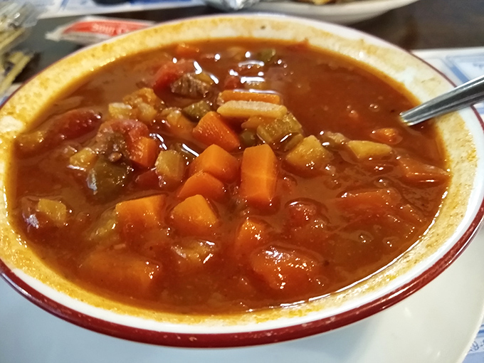 A bowl of vegetable soup that looks like someone's grandmother spent all day simmering it to perfection – chunks of vegetables and beef in every spoonful.