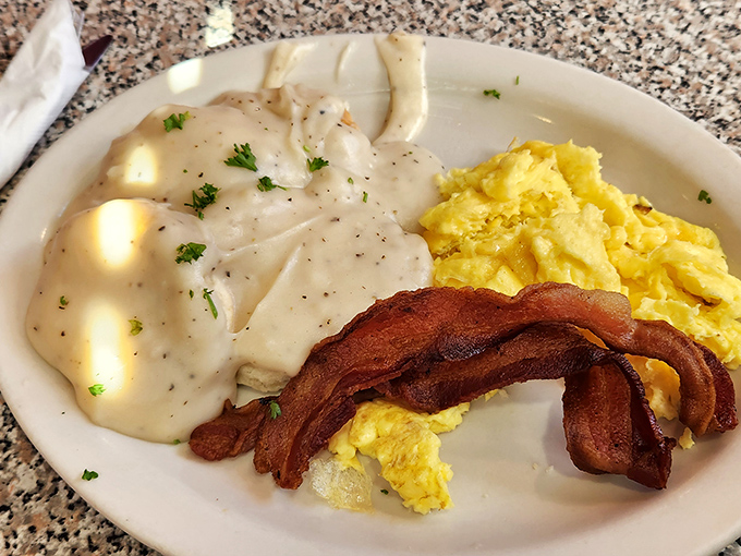 Breakfast alchemy at its finest. Creamy gravy cascades over scrambled eggs and bacon, creating the morning equivalent of a warm hug.