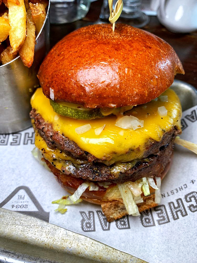 Not just a burger, but a towering monument to beef craftsmanship with melty cheese cascading down like a yellow waterfall of joy.