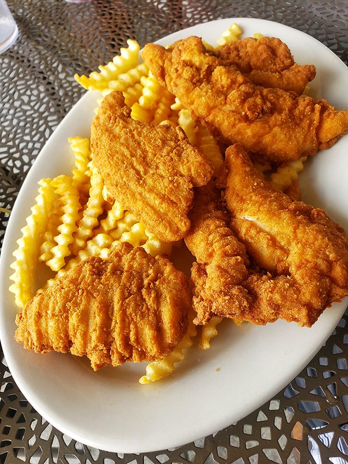 Golden-fried chicken tenders nestled among crinkle-cut fries—comfort food that speaks the universal language of "I regret nothing."