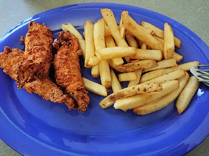 Perfectly crisp chicken tenders and fries on a blue plate—proof that sometimes the simplest comfort foods bring the most joy.