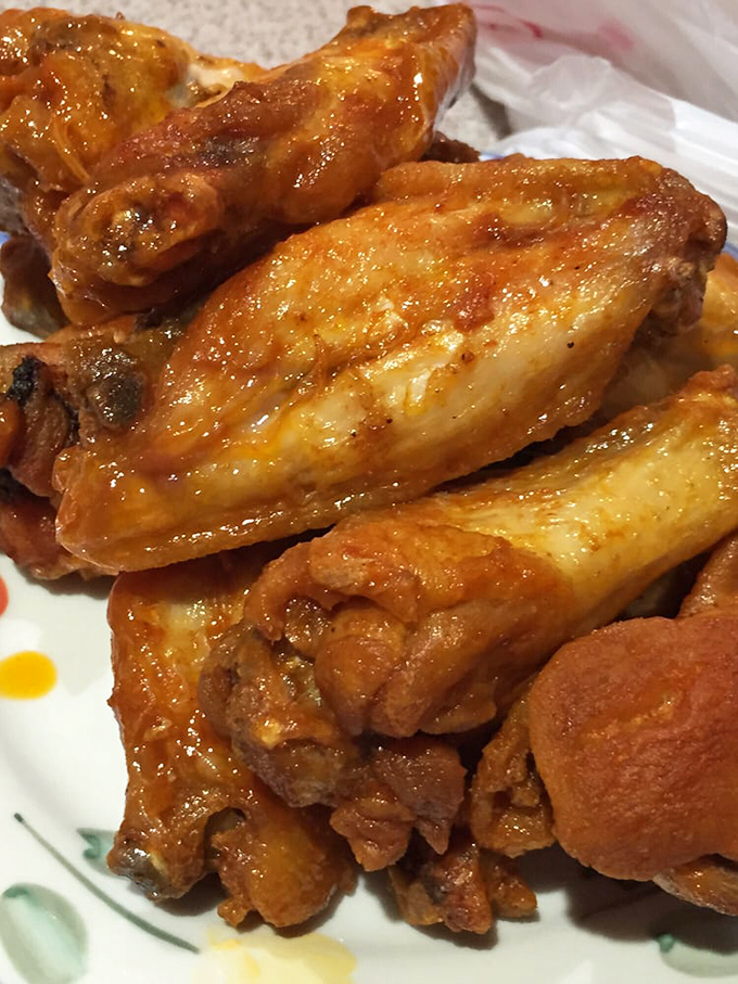 The legendary twice-fried buffalo wings glisten with sauce, promising a flavor experience that explains why locals make pilgrimages here just for these beauties.