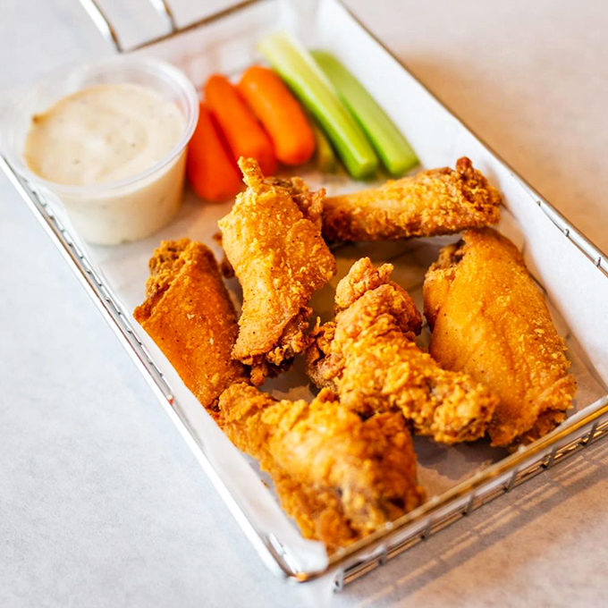 These wings aren't just served; they're presented like jewelry on tray with veggies and sauces standing by for their grand debut.
