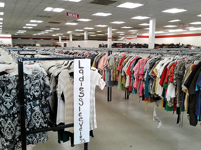 Organization is key in this textile jungle. The "Large/XL" sign stands like a lighthouse beacon guiding shoppers through the sea of secondhand style.