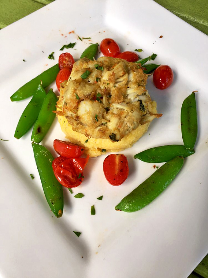 The crab cake arrives like a delicate island surrounded by a sea of vibrant vegetables&mdash;proof that seafood and garden-fresh produce are soulmates.